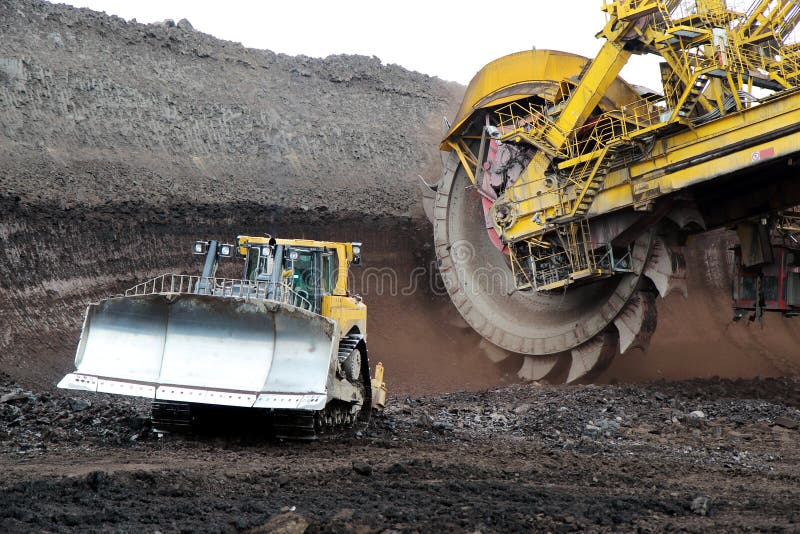 Bulldozer and Huge Mining Excavator Wheel in Brown Coal Mine Stock ...