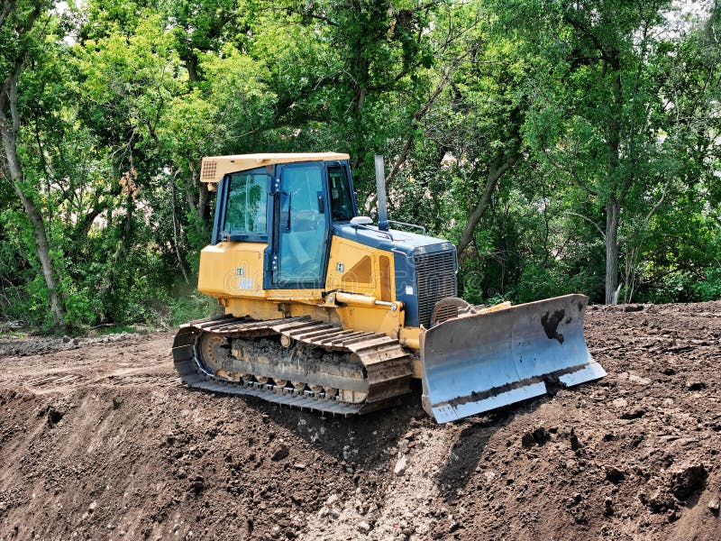 Bulldozer Leveling Off a Dirt Mound at a Construction Site Stock Image ...