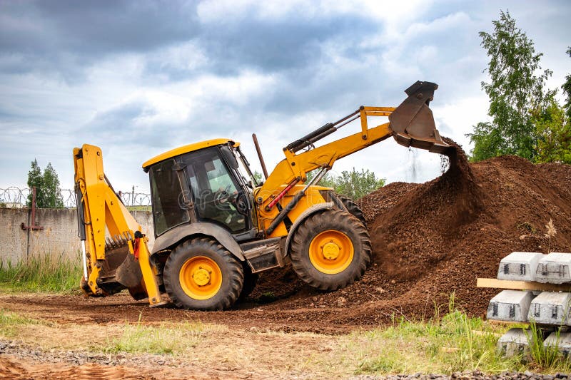 A Bulldozer or a Loader Actively Digging into a Large Pile of Dirt at a ...