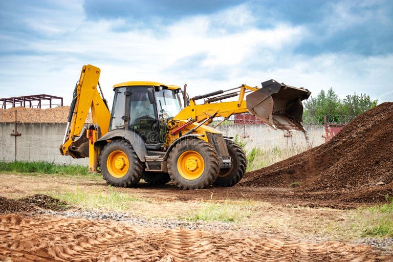 A Bulldozer or a Loader is Actively Dumping Dirt into a Growing Pile at ...