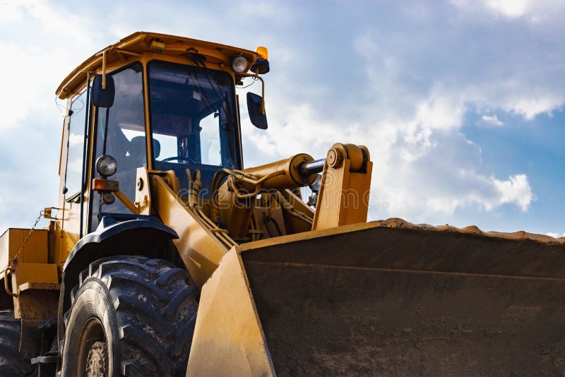 Bulldozer or Loader Moves the Earth at the Construction Site Against ...