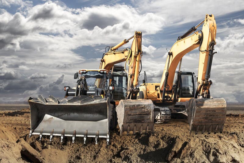 Bulldozer or Loader Moves the Earth at the Construction Site Against ...