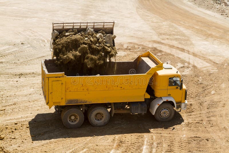 Bulldozer loading truck stock photo. Image of quarry - 78340074
