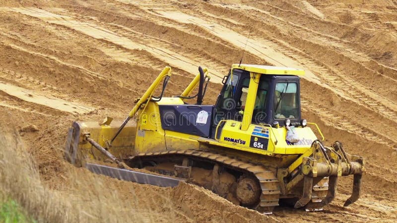 Bulldozer Working on a Construction Site, Leveling a Mound of Sand ...