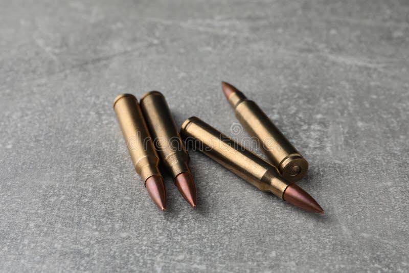 Bullets on Light Grey Table, Closeup. Firearm Ammunition Stock Image ...