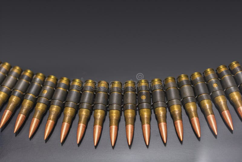 Bullets of Linked Ammunition Lined Up in Row on a Black Background ...