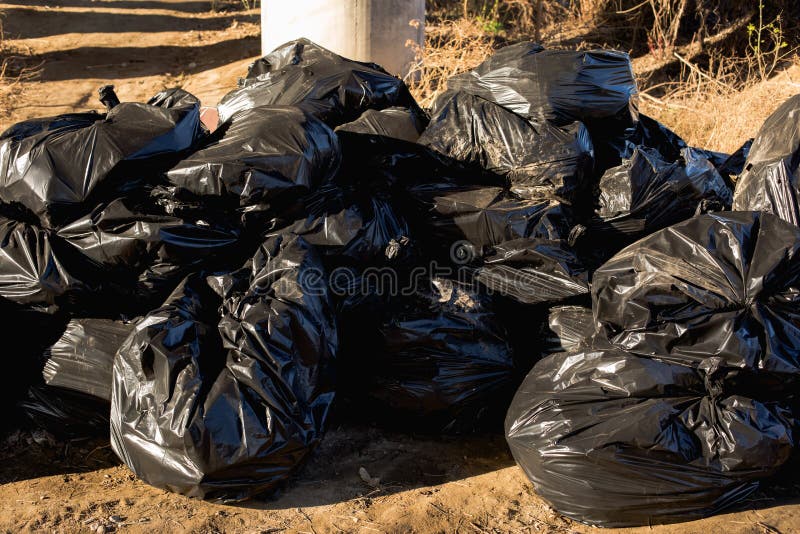 A Bunch of Black Plastic Garbage Bags. the Garbage is Scattered Around ...