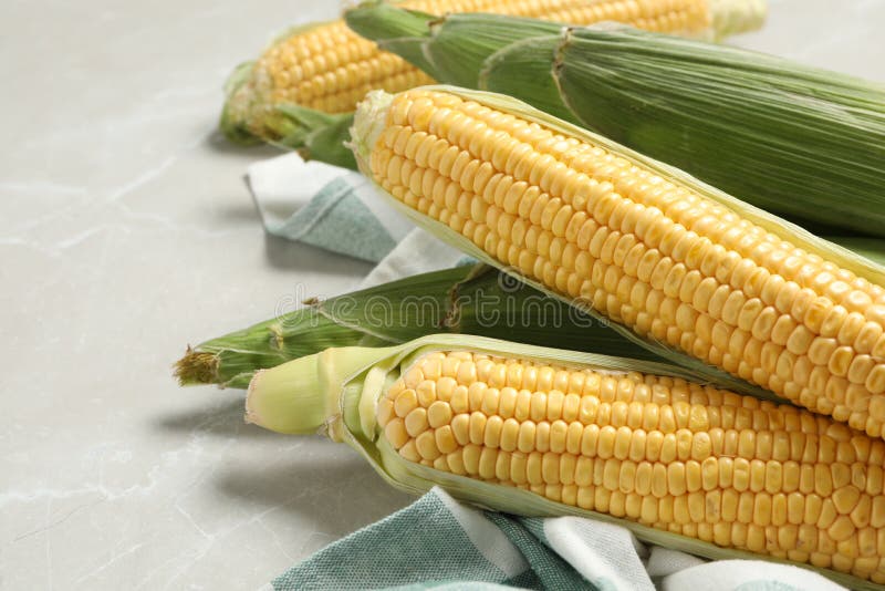 Bunch of Corn Cobs on Light Marble Table, Closeup Stock Photo - Image ...