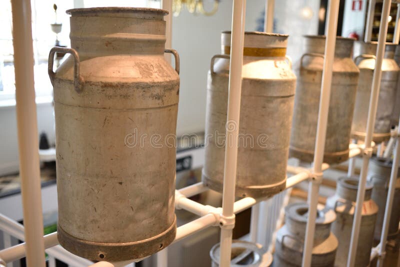 A Bunch of Old Rusty and Battered Milk Cans on Top of Racks Stock Image ...