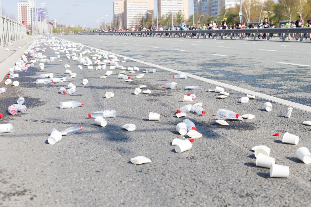 A Bunch of Plastic Cups and Empty Bottles on the Streets while a ...