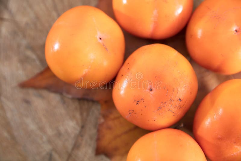 A Bunch of Ripe Crispy Persimmons on a Yellow Leaf Stock Photo - Image ...