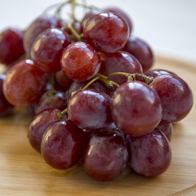 Bunch of Ripe Red Grape on a Round Bamboo Board, Side View. Close-up ...