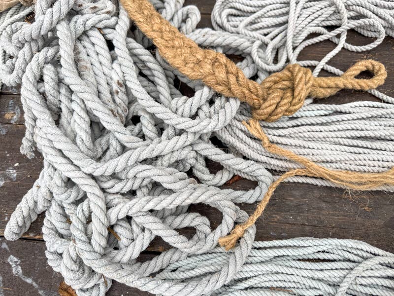 A Bunch of Ropes of Different Colors and Sizes are Piled on a Wooden ...