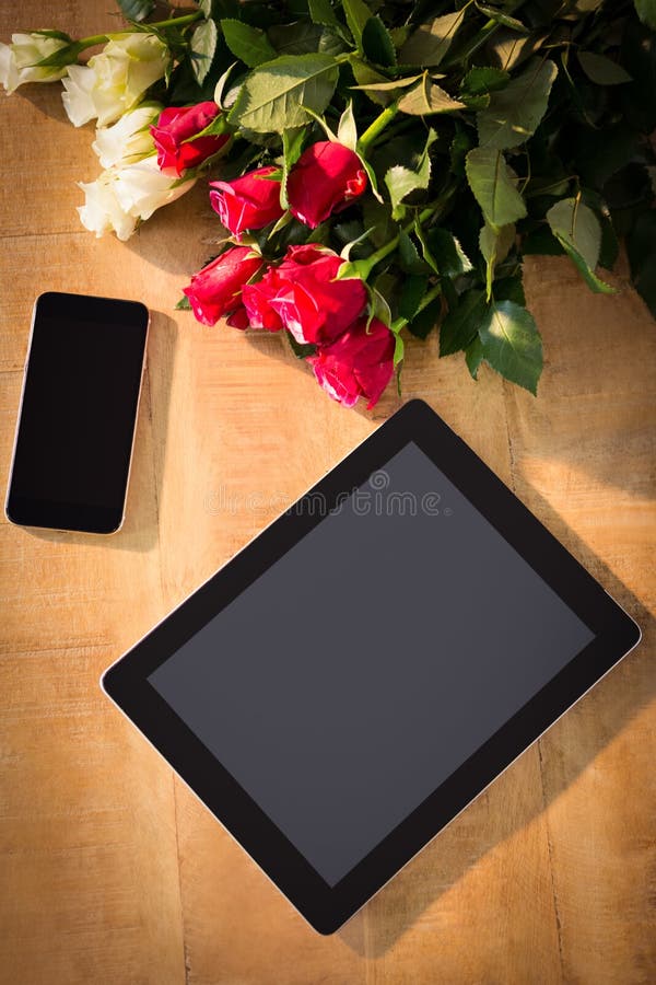 Bunch of Roses with Smartphone and Digital Tablet on the Wooden Table ...