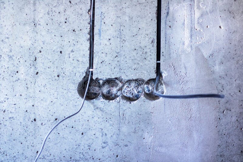 A Bunch of Various Wires are Hanging Down from a Concrete Wall Stock ...