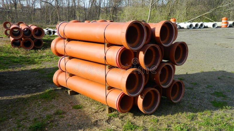 Bundle of New Red Drainage Pipes Stock Photo - Image of road ...
