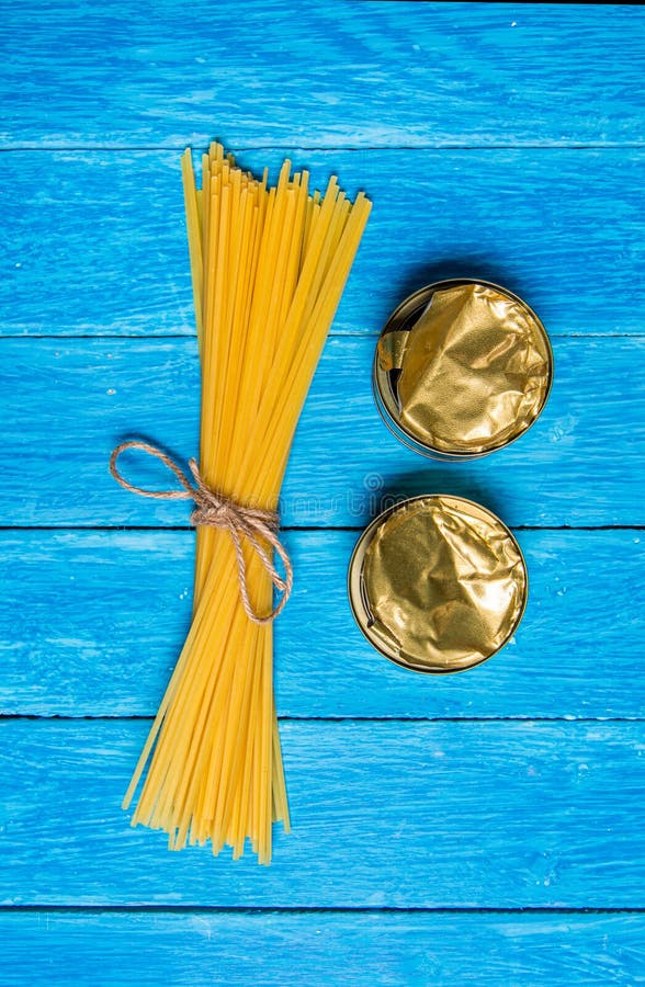 Bundle of Spaghetti Tied with String and Two Opened Cans on Wooden Blue ...