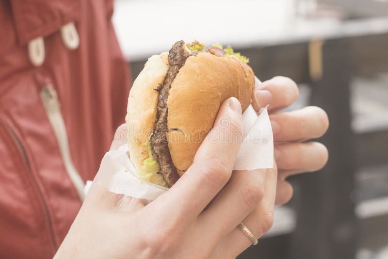 Burger in the hand. stock photo. Image of fastfood, bite - 130571148