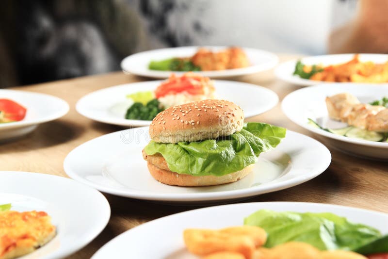 Burger and a Plate of Delicious Dishes on the Table in the Restaurant ...