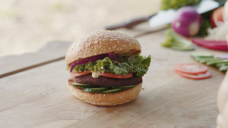 Burger Shot on the Wooden Surface with Ingredients in the Background ...
