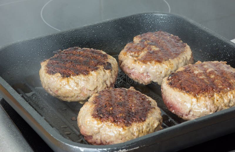 Burgers, Beef in a Frying Pan on Cooking Surface in Kitchen Stock Image ...