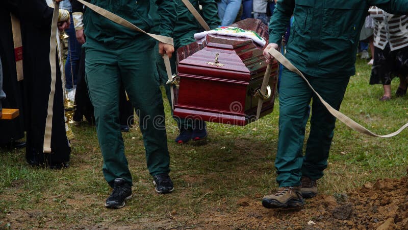 Burial. Men Lower the Coffin into the Grave. N Stock Photo - Image of ...