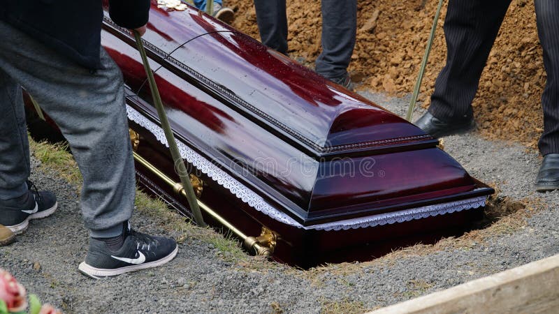 Burial. Men Lower the Coffin into the Grave. N Stock Photo - Image of ...