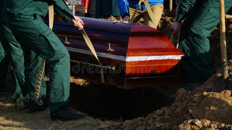 Burial. Men Lower the Coffin into the Grave Stock Image - Image of ...