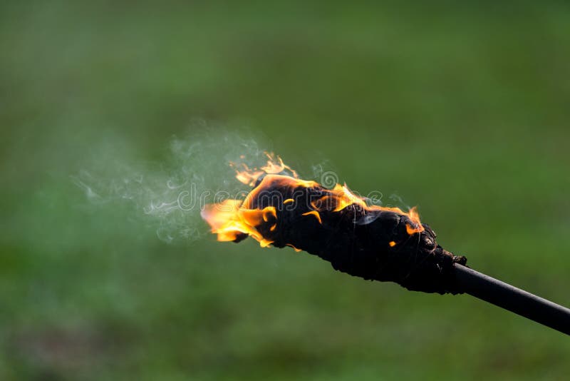 Burning Flame of a Torch on Green Grass Background before Nighttime ...