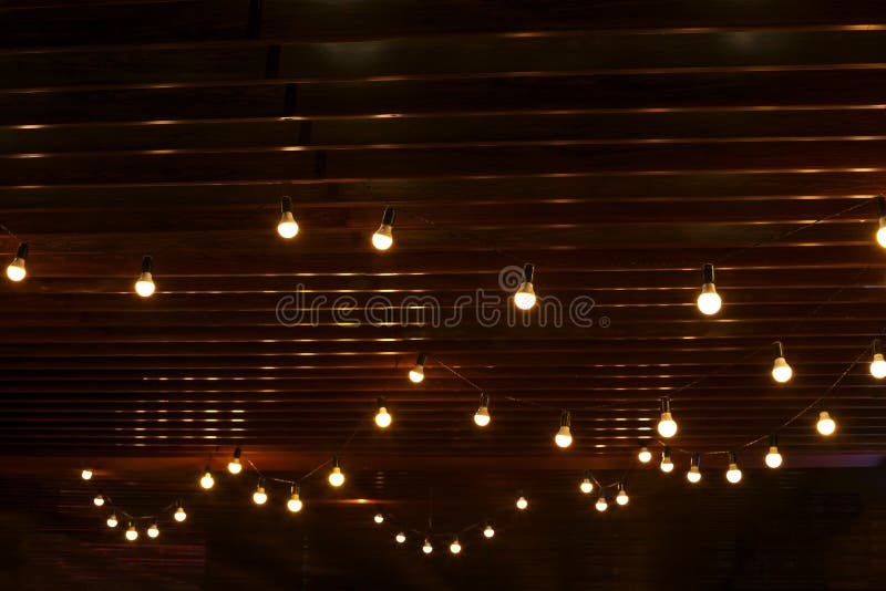 Burning Light Bulbs on a Wooden Wall Background Stock Image - Image of ...