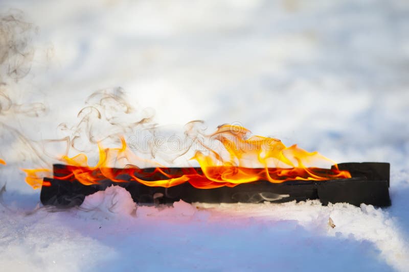 Burning log in the snow stock photo. Image of coal, phenomenon - 297921478