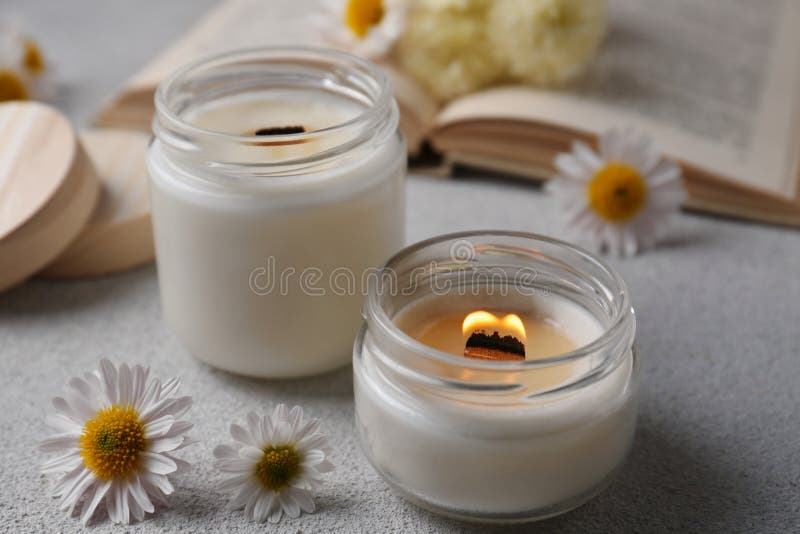 Burning Scented Candles and Chamomile Flowers on Light Gray Textured ...
