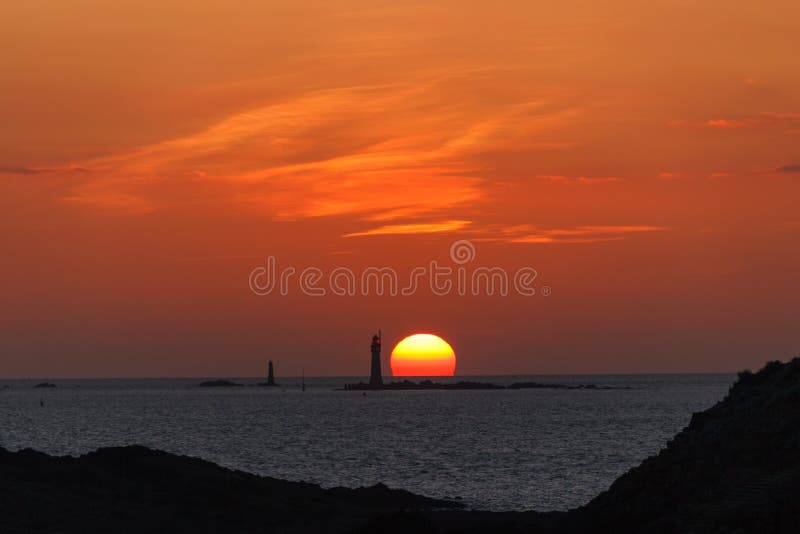 Burning Sunset in Ocean with a Lighthouse Stock Photo - Image of scene ...