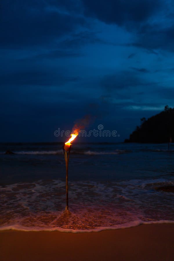 Burning Torch on the Sandy Beach of the Ocean Stock Photo - Image of ...