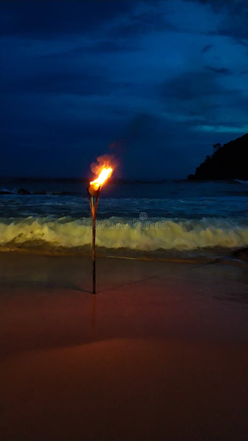 Burning Torch on the Sandy Beach of the Ocean Stock Photo - Image of ...