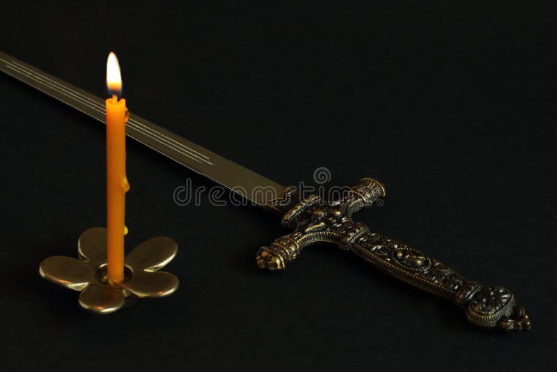 Burning Wax Candle on Bronze Candlestick in Shape of Flower and Dagger ...