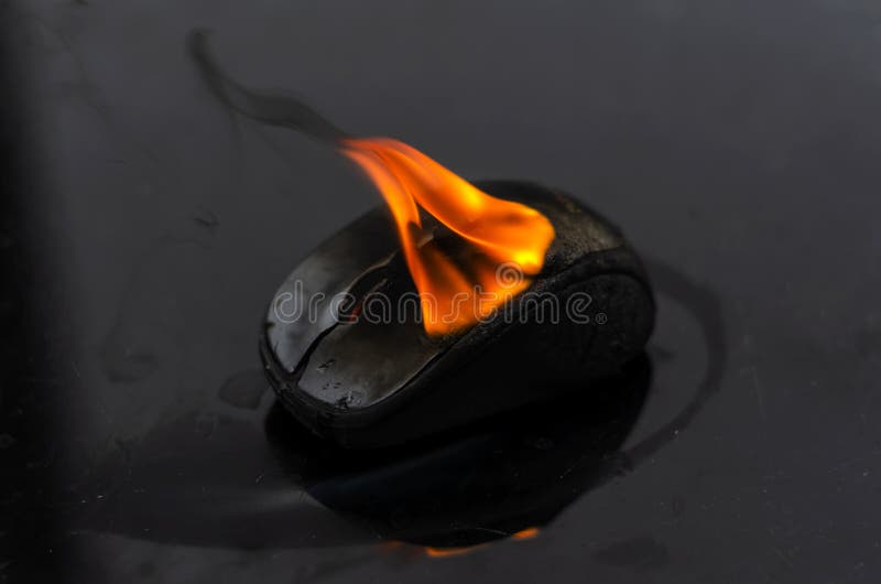 Burning Wireless Computer Mouse on a Black Table Stock Image - Image of ...