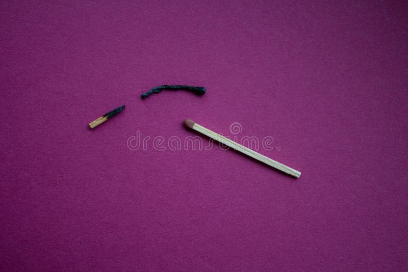 A Burnt Match Broken in Half and Whole Match on Purple Background Stock ...