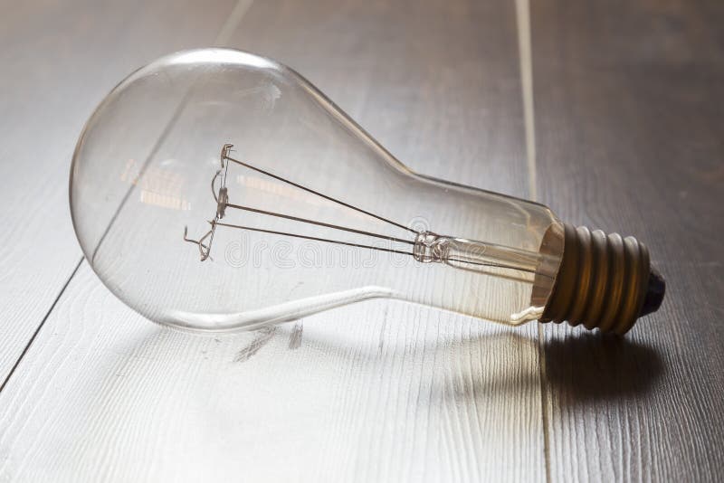 Burnt Out Light Bulb on Wooden Surface Stock Photo - Image of ...