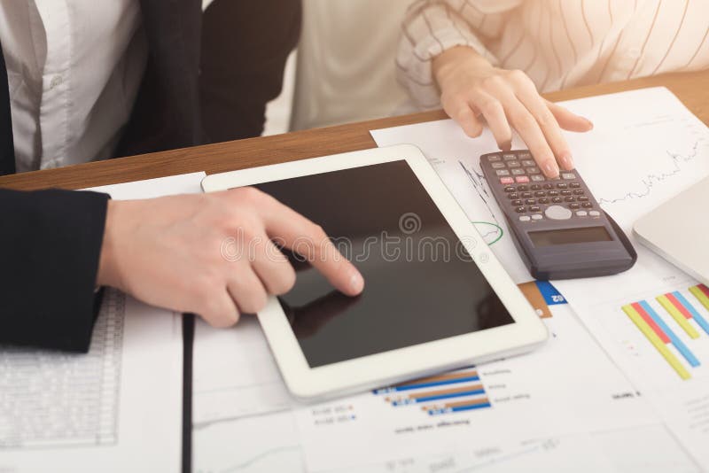 Business Colleagues Counting on Calculator and Using Tablet Stock Image ...