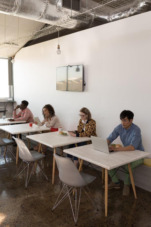 Business Colleagues Using Multimedia Devices in Canteen Stock Photo ...