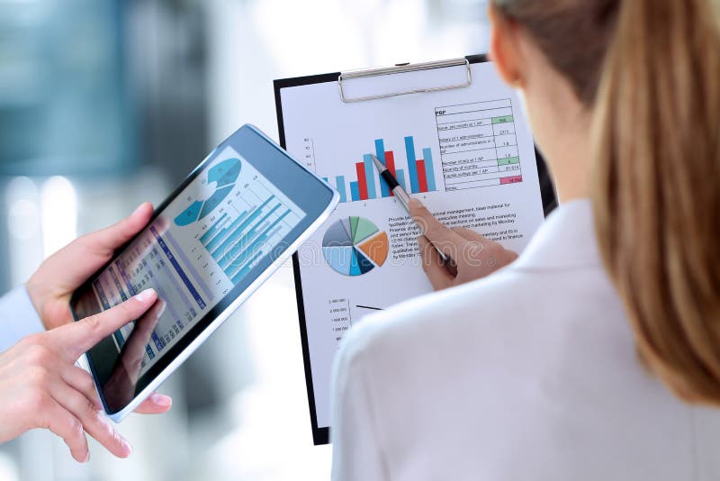 Business Colleagues Working and Analyzing Financial Figures on a Graphs ...