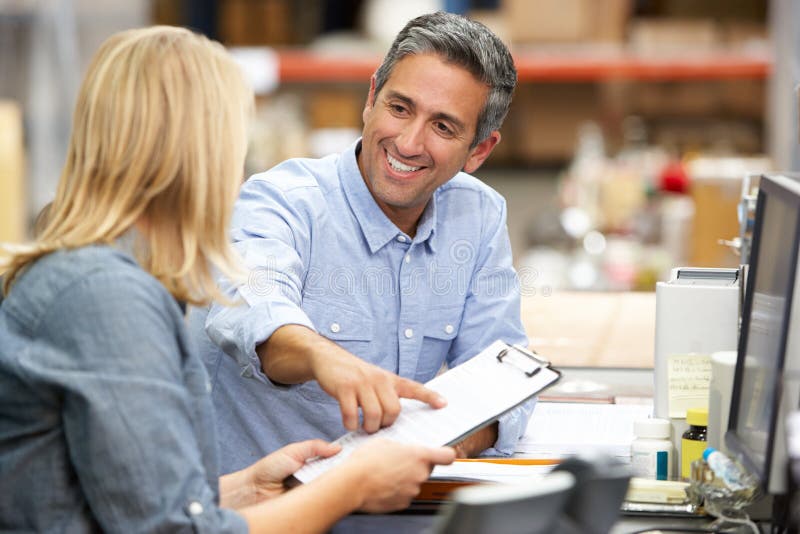 Business Colleagues Working at Desk in Warehouse Stock Photo - Image of ...
