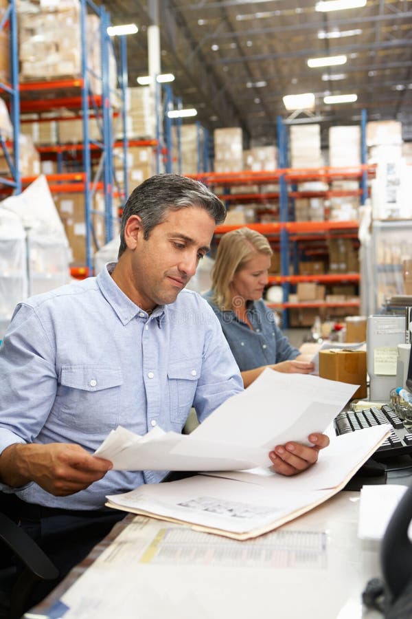 Business Colleagues Working at Desk in Warehouse Stock Photo - Image of ...