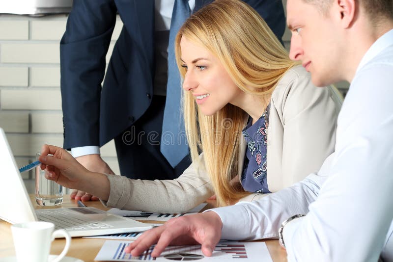 Business Colleagues Working Together and Analyzing Financial Figures on ...