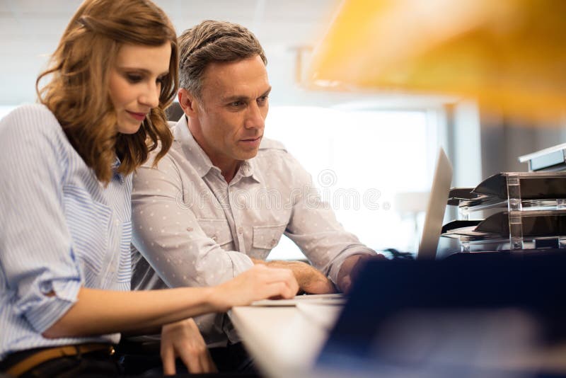 Business Colleagues Working Together on Laptop at Desk Stock Photo ...