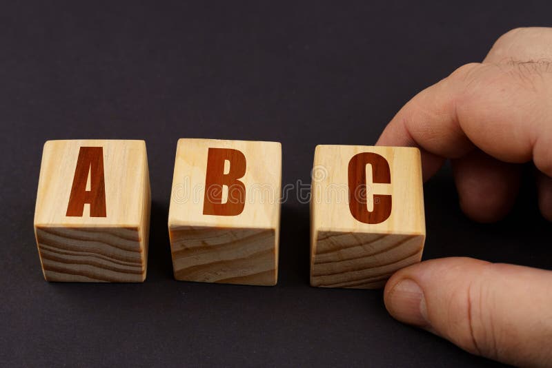 On a Black Surface, a Man Puts Cubes with the Inscription - ABC Stock ...