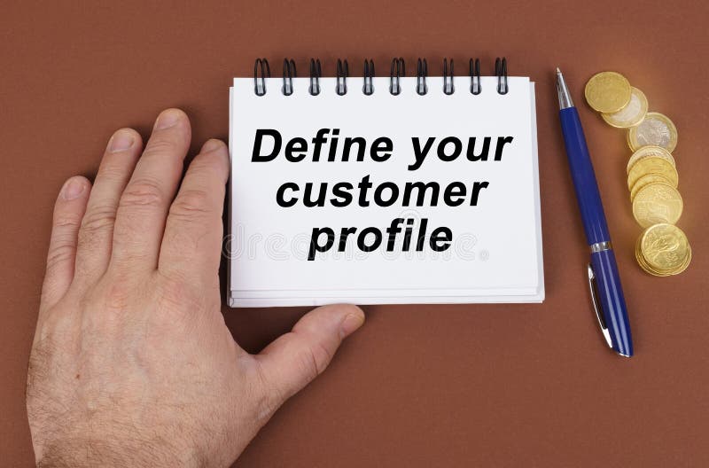 On a Brown Surface are Coins, a Pen and a Notepad with the Inscription ...