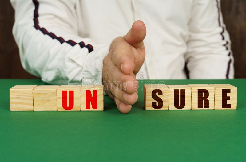 A Man Separates the Cubes with the Inscription - UNSURE or SURE Stock ...