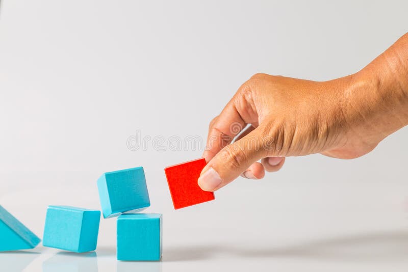 Business Disruption Ideas Concept. Man Hand Pulling Red Wood Block from ...